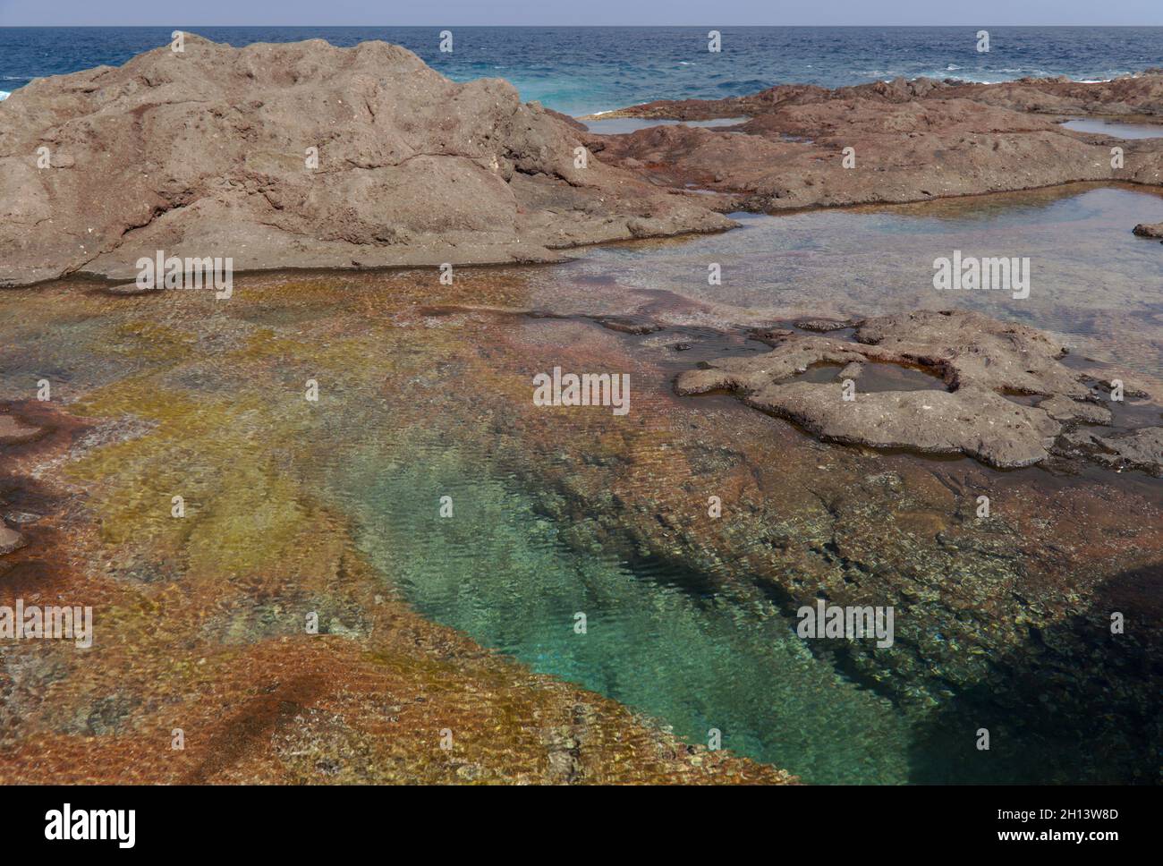 Gran Canaria, calm rock pools under steep cliffs of the north coast are ...