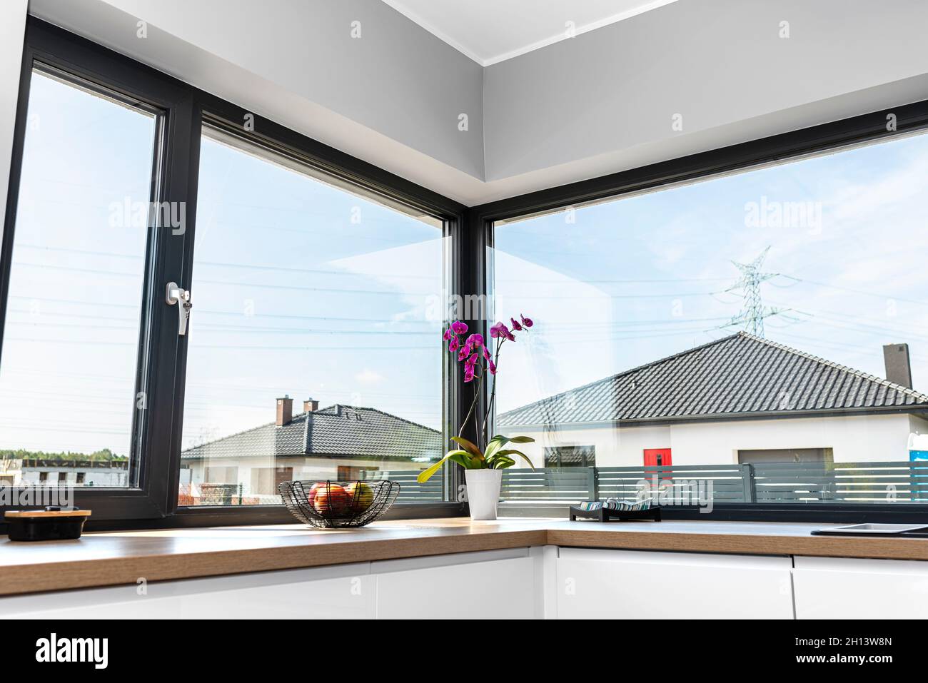 Large corner window in a modern kitchen with built-in cabinets against ...