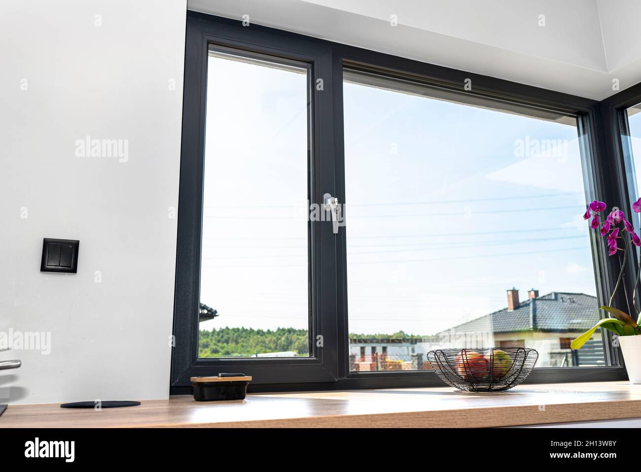 Large corner window in a modern kitchen with built-in cabinets against ...