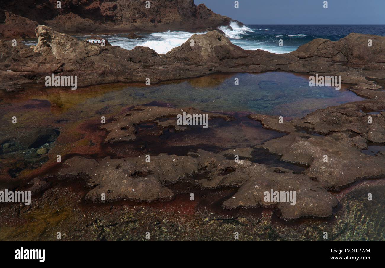 Gran Canaria, calm rock pools under steep cliffs of the north coast are ...
