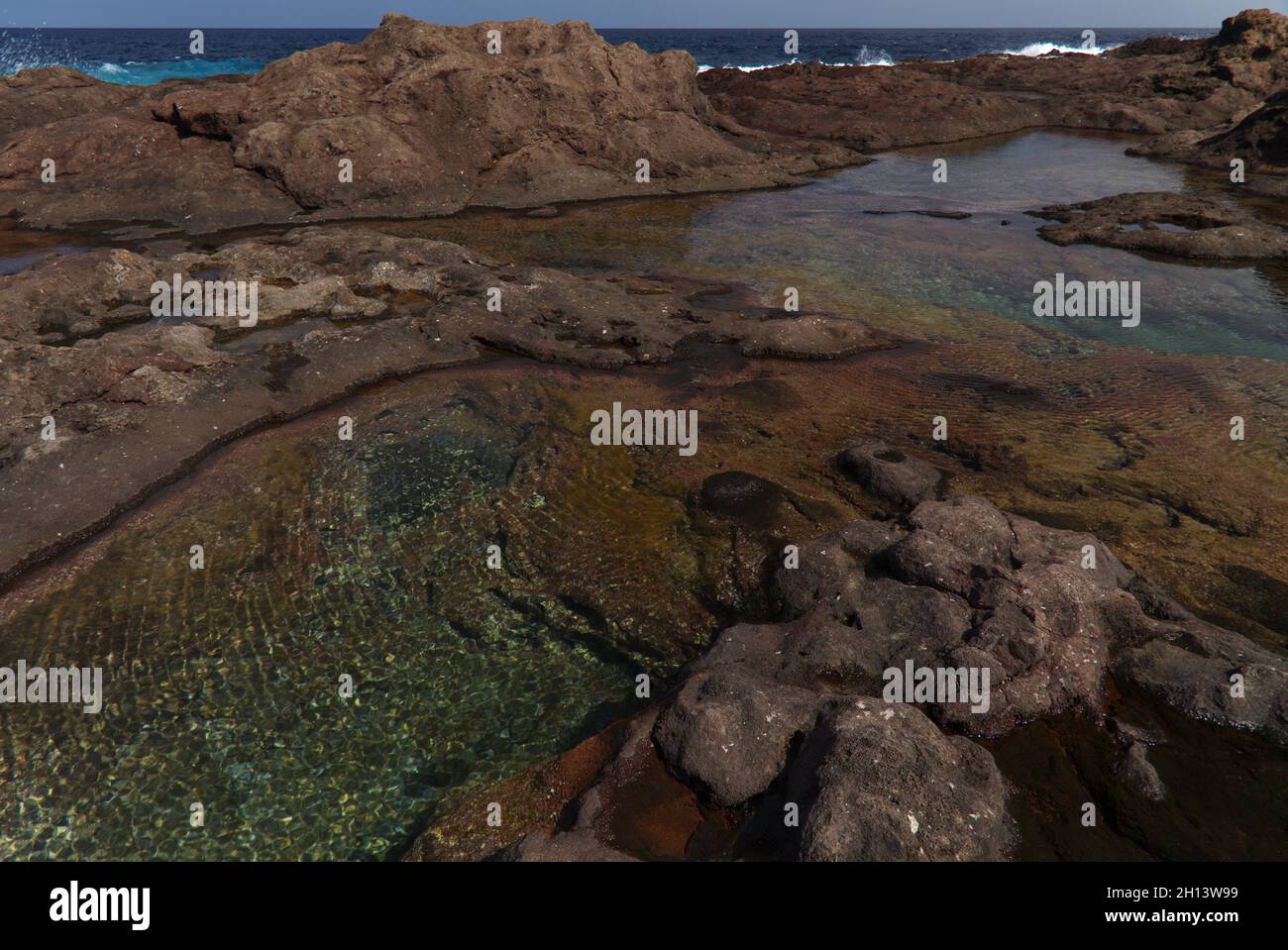 Gran Canaria, calm rock pools under steep cliffs of the north coast are ...