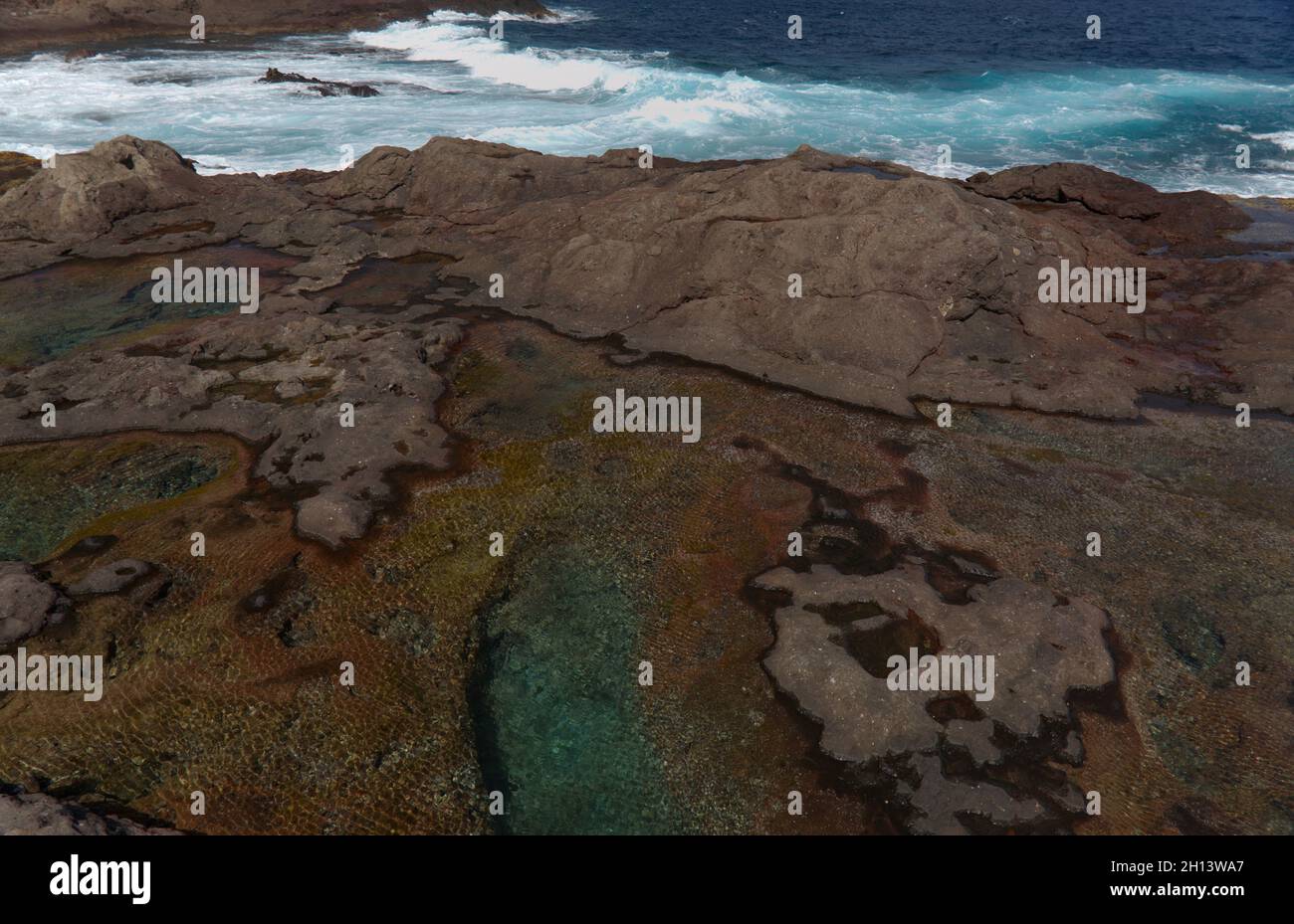 Gran Canaria, calm rock pools under steep cliffs of the north coast are ...
