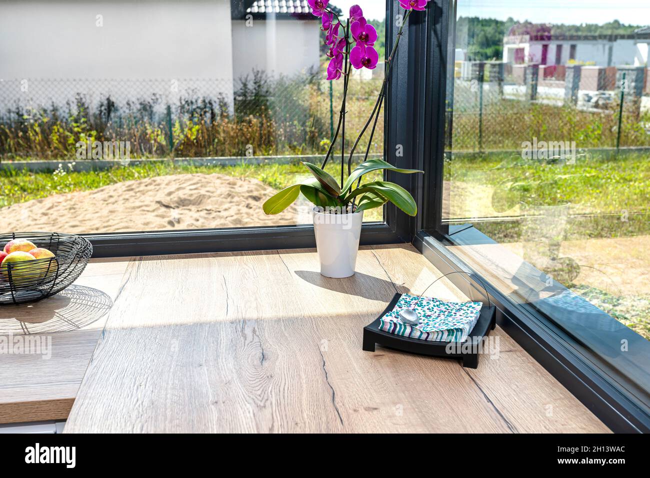 Large corner window in a modern kitchen with built-in cabinets against ...