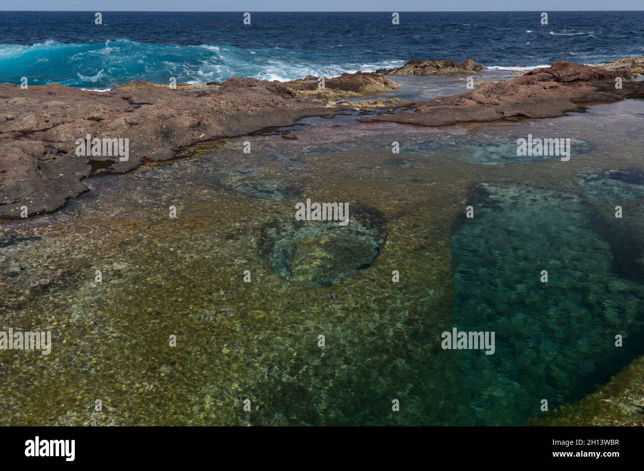 Gran Canaria, calm rock pools under steep cliffs of the north coast are ...