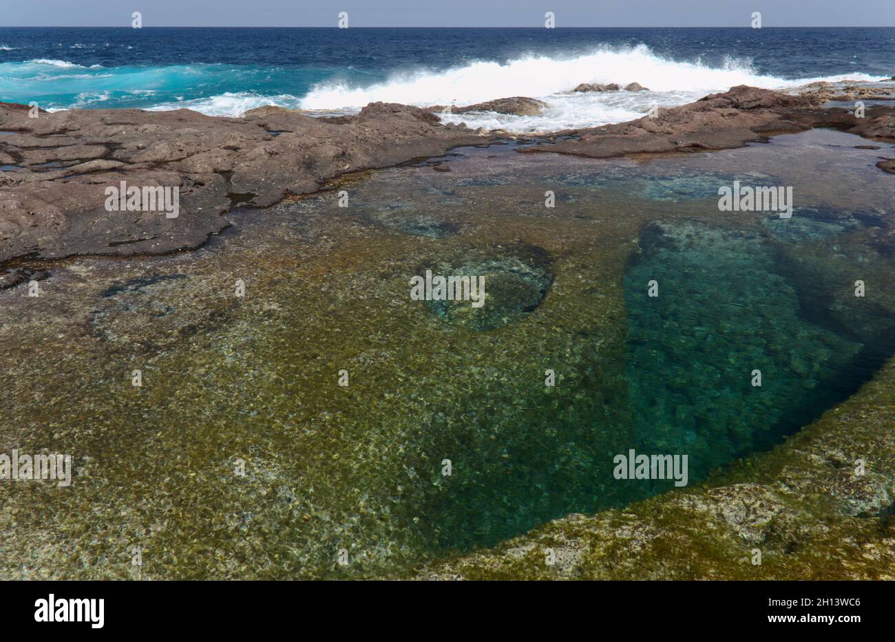 Gran Canaria, calm rock pools under steep cliffs of the north coast are ...