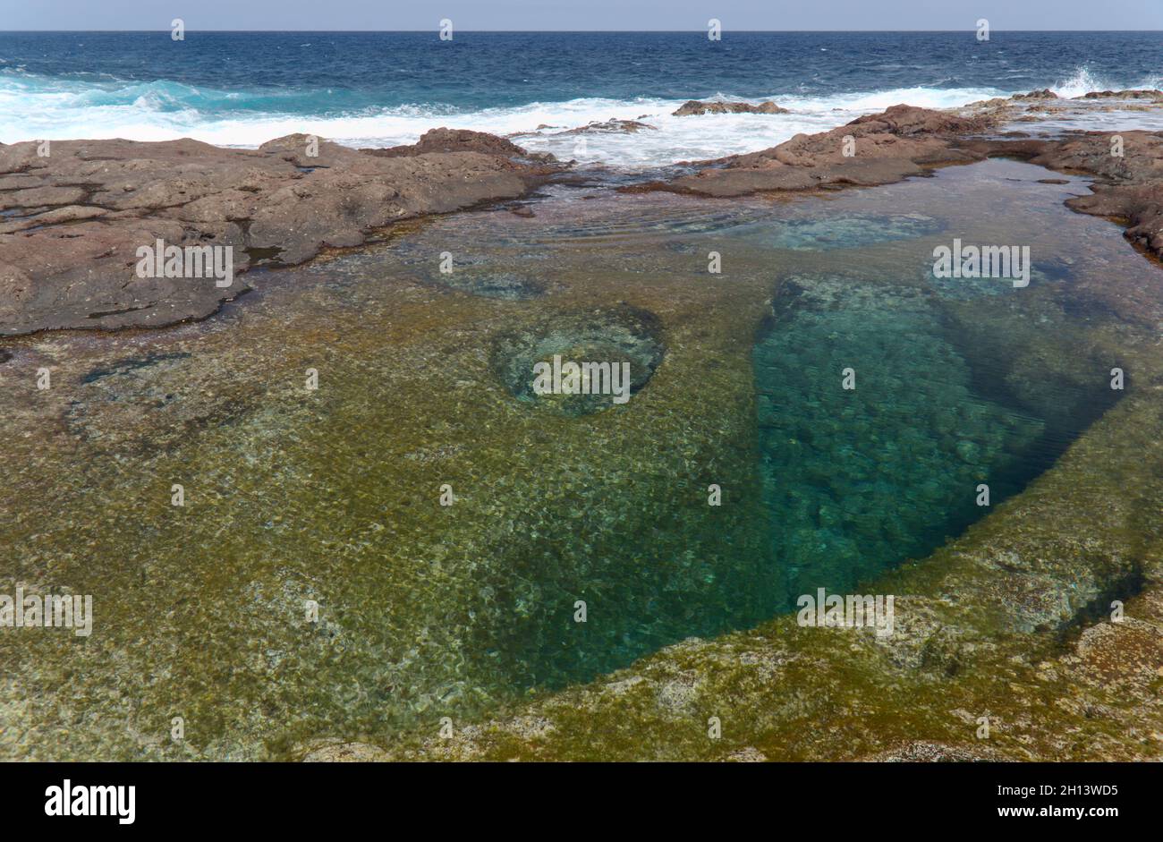 Gran Canaria, calm rock pools under steep cliffs of the north coast are ...