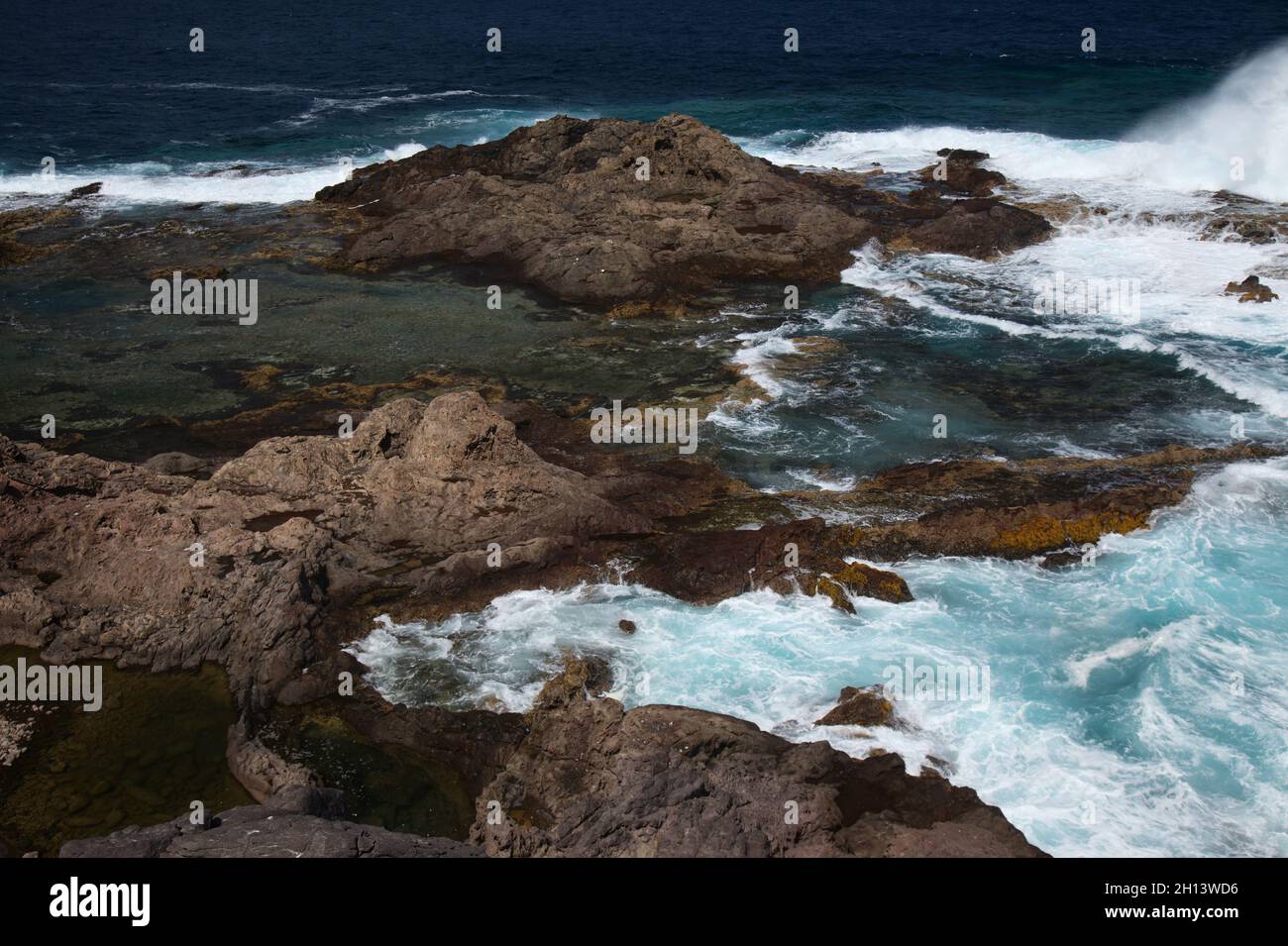 Gran Canaria, calm rock pools under steep cliffs of the north coast are ...