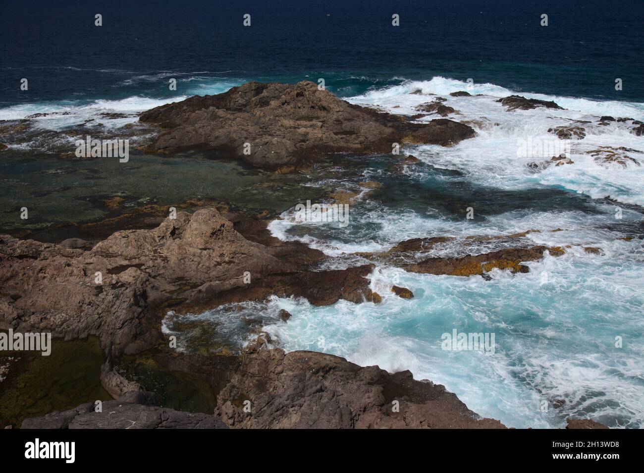 Gran Canaria, calm rock pools under steep cliffs of the north coast are ...