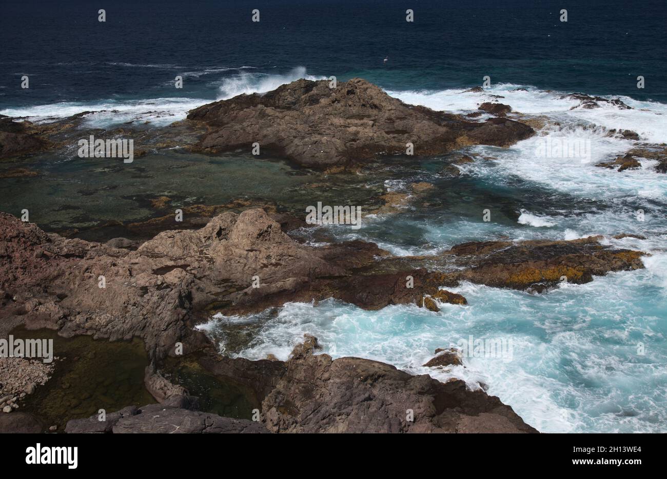Gran Canaria, calm rock pools under steep cliffs of the north coast are ...