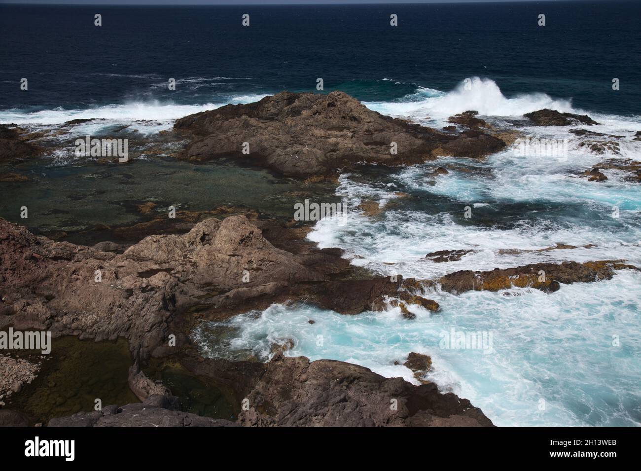 Gran Canaria, calm rock pools under steep cliffs of the north coast are ...