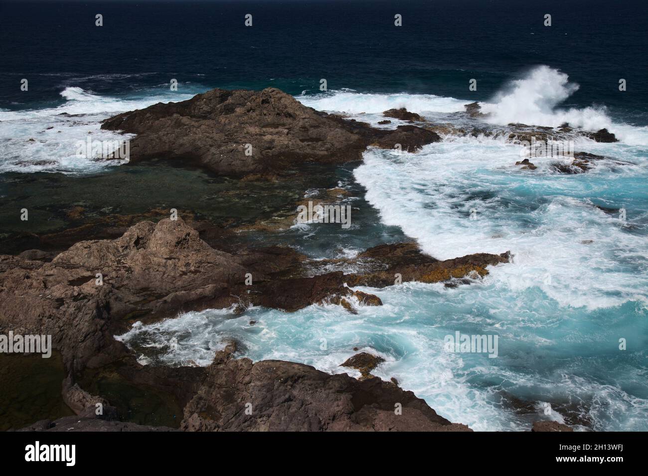 Gran Canaria, calm rock pools under steep cliffs of the north coast are ...