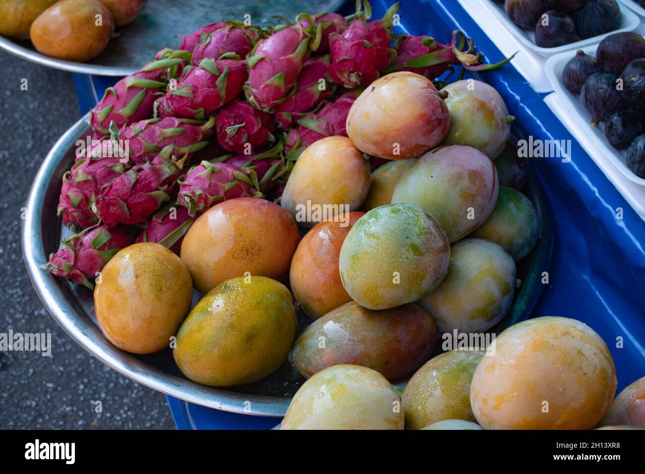 Mango and dragon fruits on display at farmer's market. Exotic fruits ...