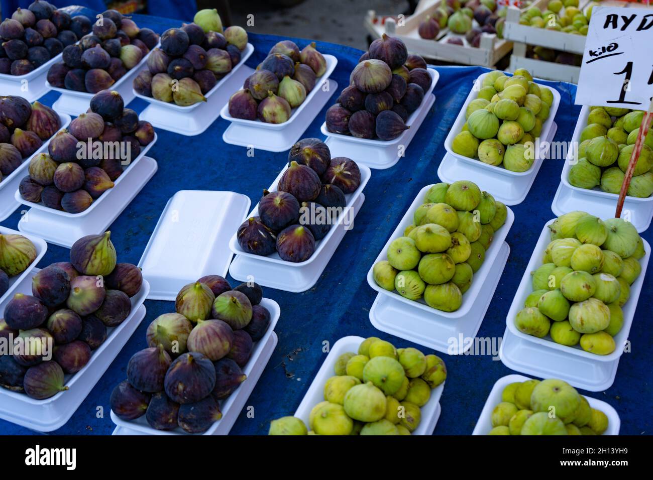 Fresh figs packaged on plastic substrates on the counter on farmer's ...