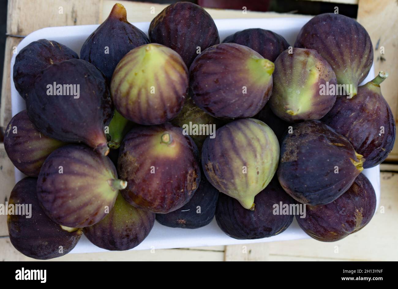 Fresh purple figs packaged on plastic substrates on the counter on ...