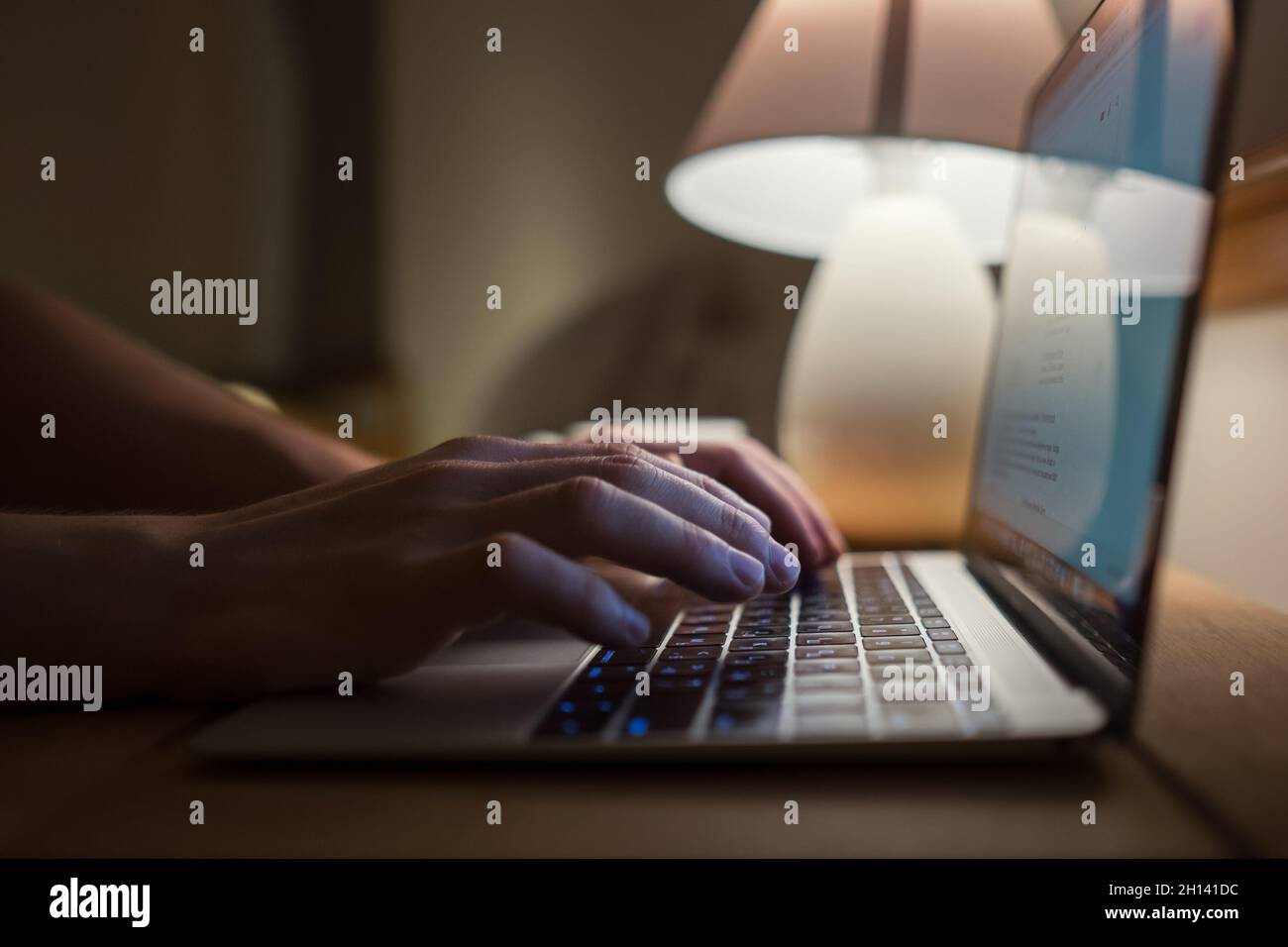 Writer typing modern computer keyboard writing novel in the evening ...