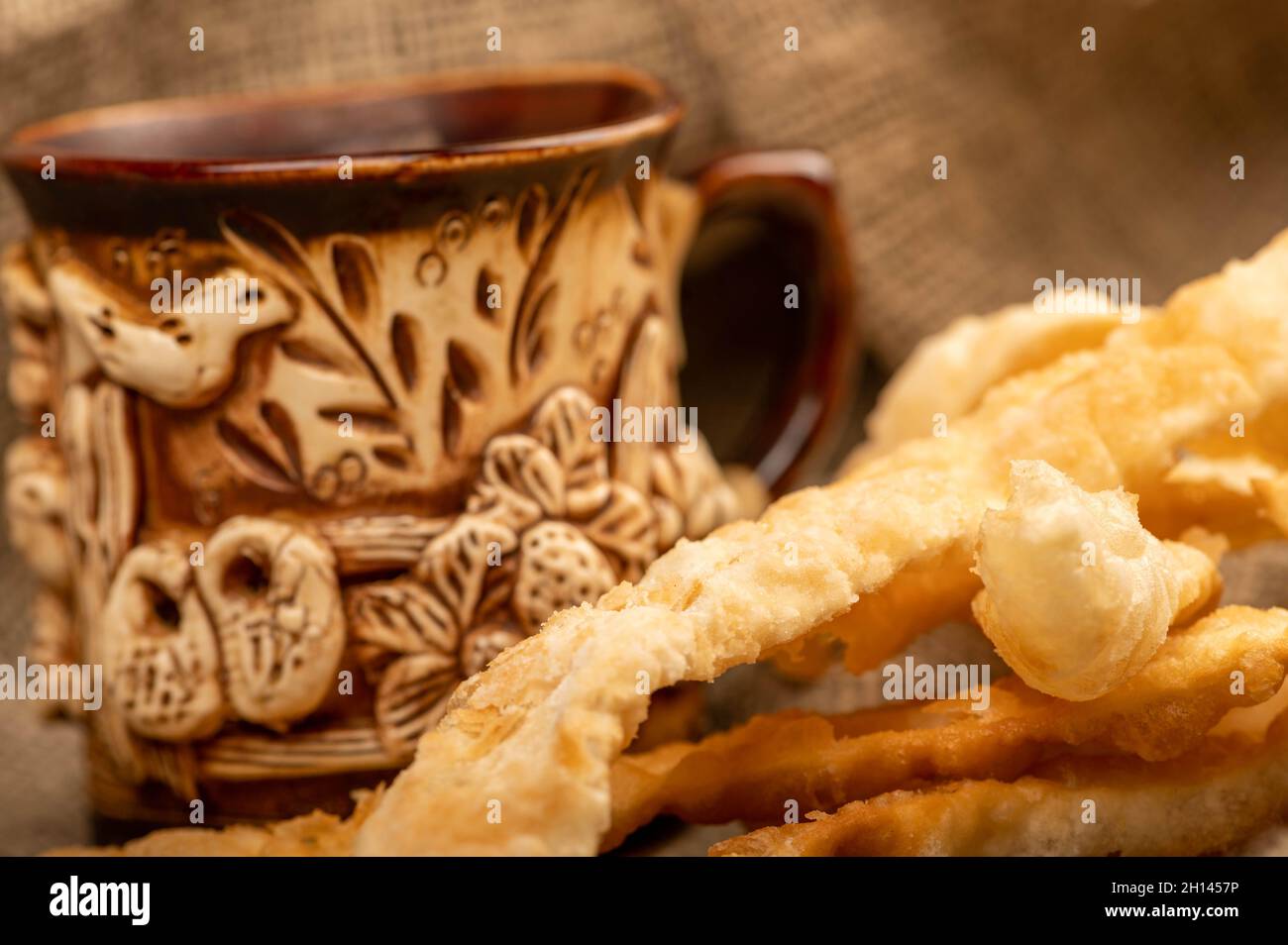 Fried bread sticks with salt and a ceramic mug, close-up, selective ...
