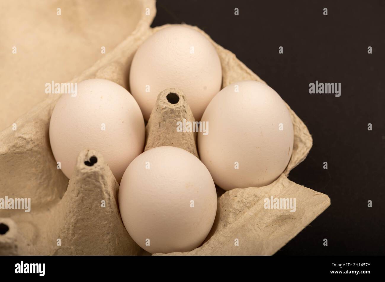 White chicken eggs in a tray made of white cardboard, close-up ...