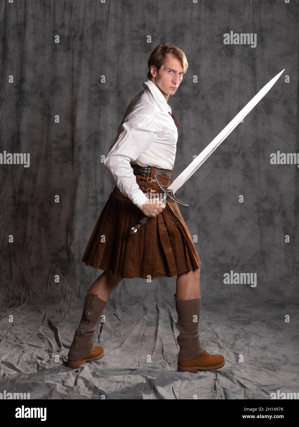 A young man in a leather kilt and a white lace-up blouse. A Scottish ...