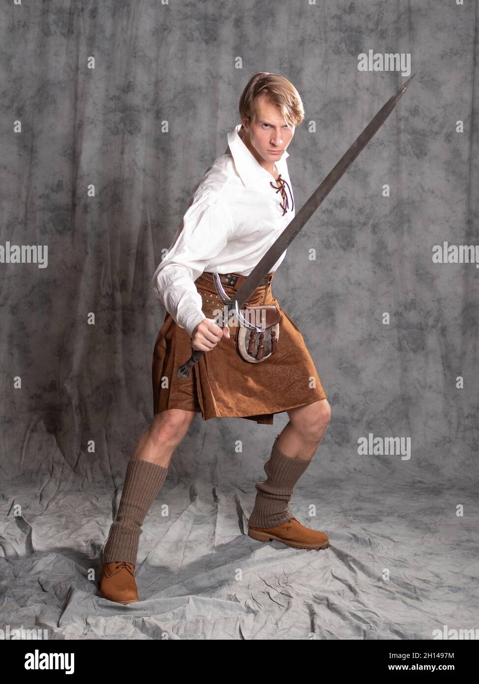 A young man in a leather kilt and a white lace-up blouse. A Scottish ...