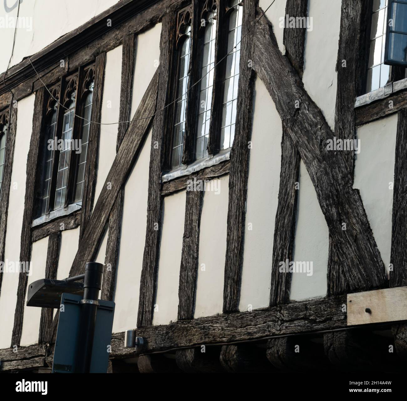 Close up side of Tudor timber framed cottage house with tall windows at ...