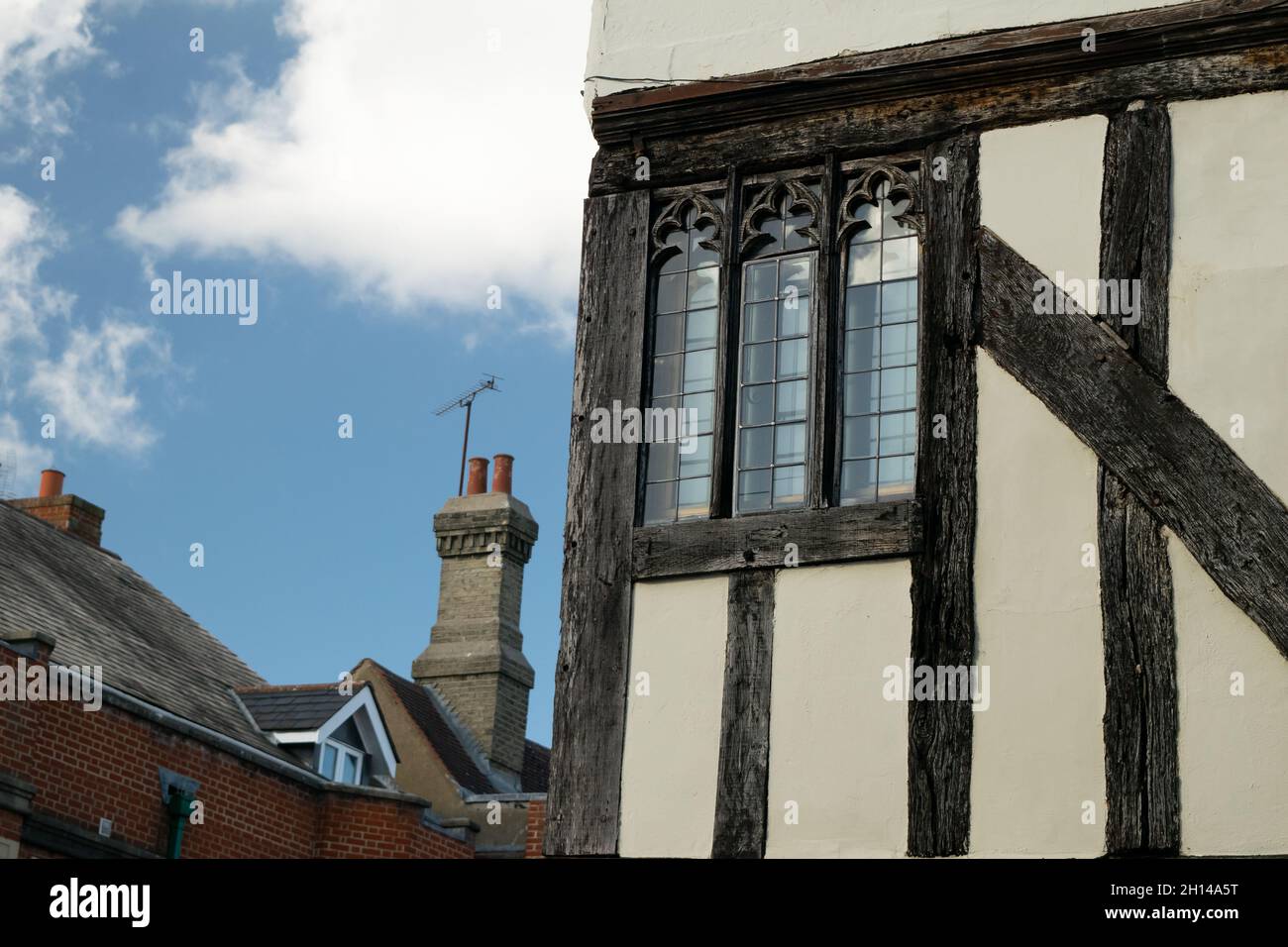 Close up side of Tudor timber framed cottage house with tall windows at ...