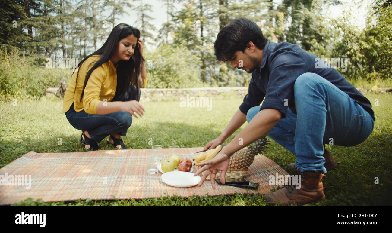 Shot of South Asian friends in India preparing for a picnic with fruits ...