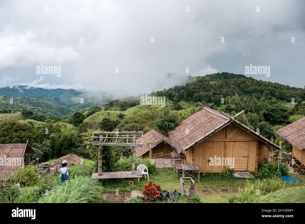 Wooden thatched hut resort on hill among mountain in tropical ...