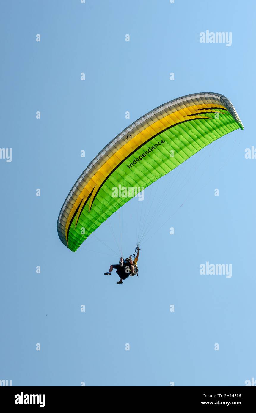 Tandem green and yellow-colored parachute against clear blue sky Stock ...
