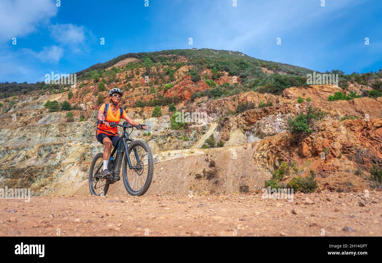 nice active woman riding her electric mountain bike in the abandoned ...