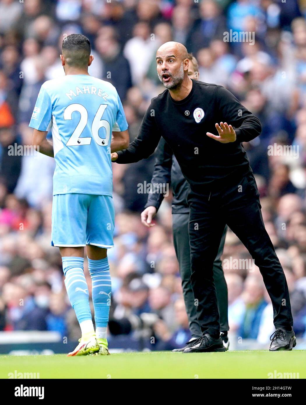 Manchester City manager Pep Guardiola (right) speaks to Riyad Mahrez ...