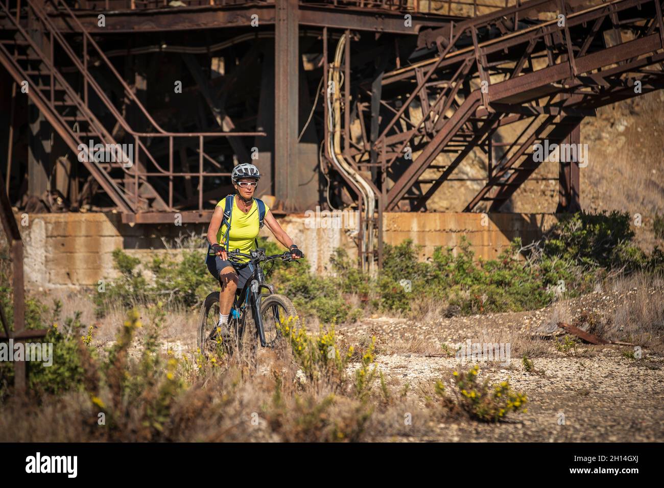 nice active woman riding her electric mountain bike in the abandoned ...