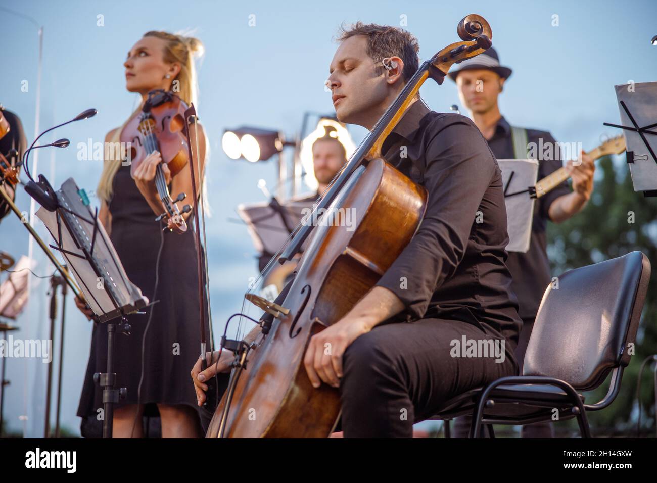 Male cellist playing in orchestra at outdoor concert Stock Photo - Alamy