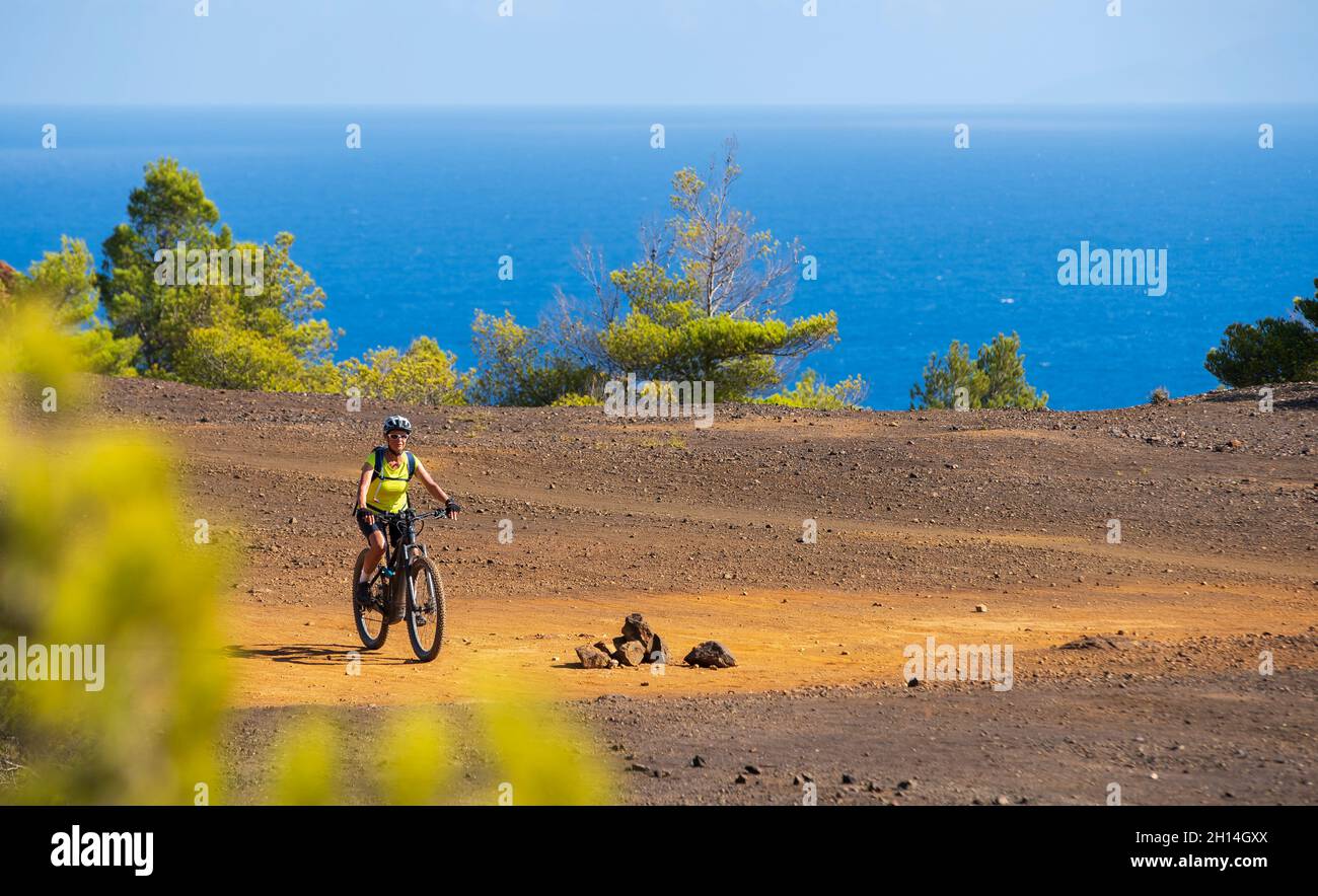 nice active woman riding her electric mountain bike in the abandoned ...