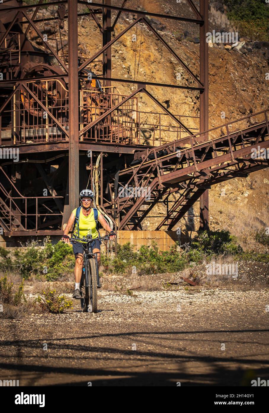 nice active woman riding her electric mountain bike in the abandoned ...