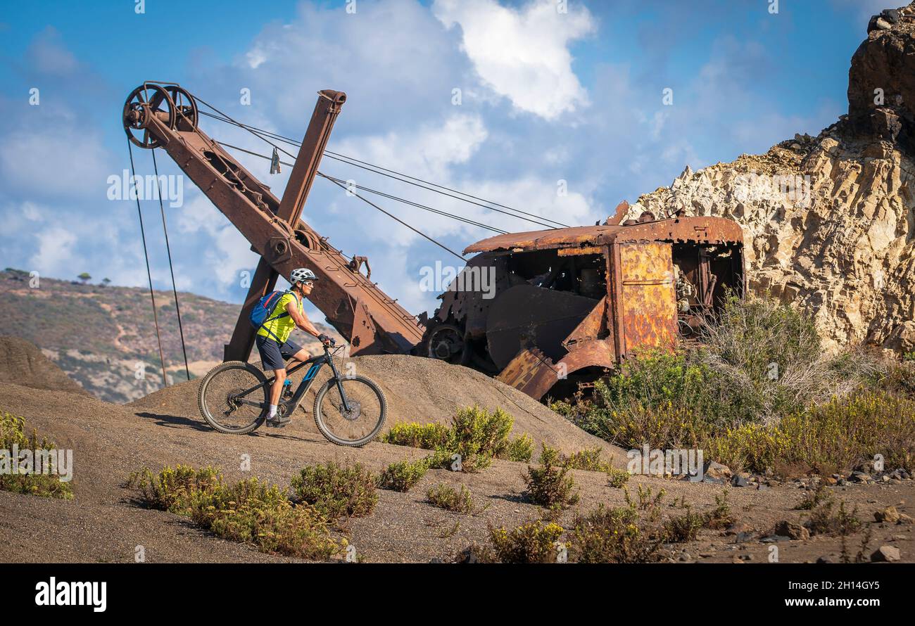 nice active woman riding her electric mountain bike in the abandoned ...