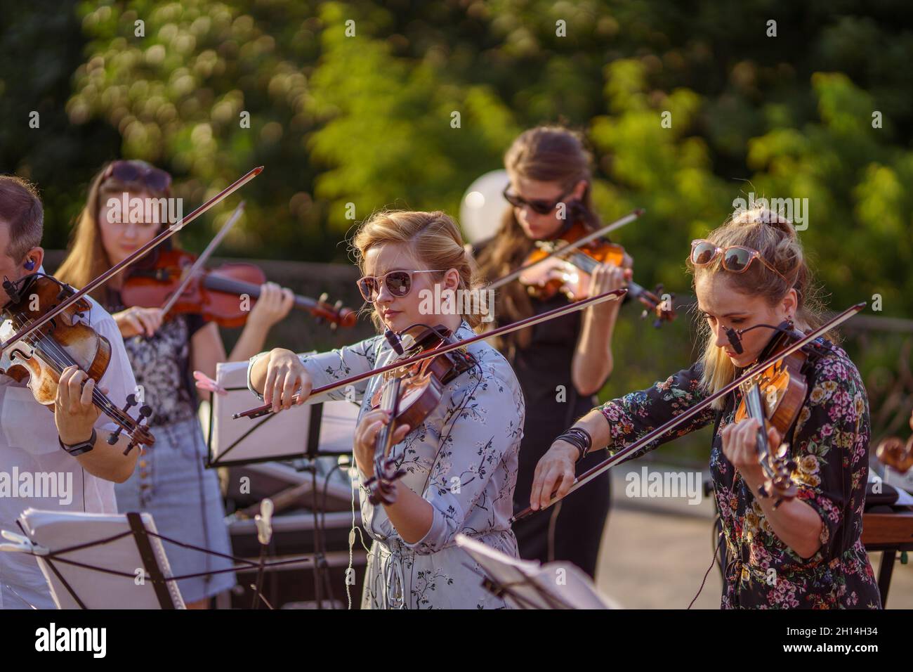 Musical ensemble playing violin at outdoor concert Stock Photo - Alamy