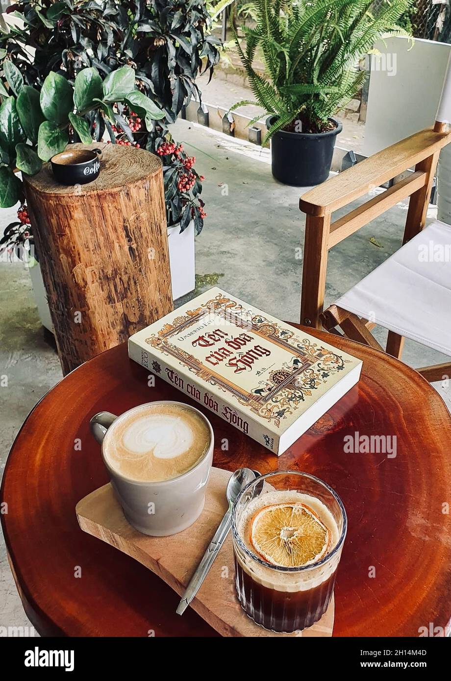 Saigon, Vietnam - May 22, 2021. Hot coffee with a book on wooden table ...