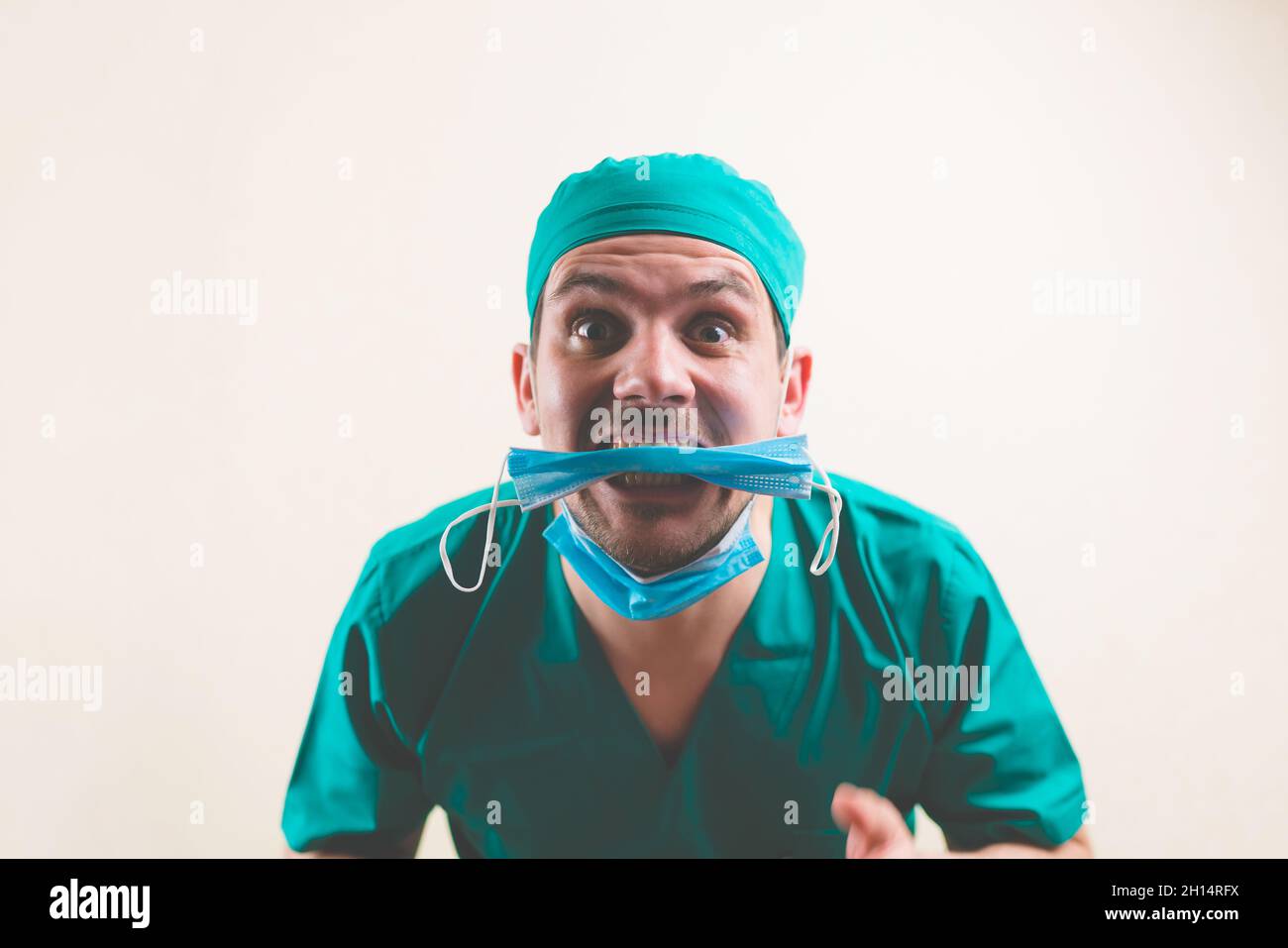 Young doctor in green surgeon suit with protective breathing mask in ...