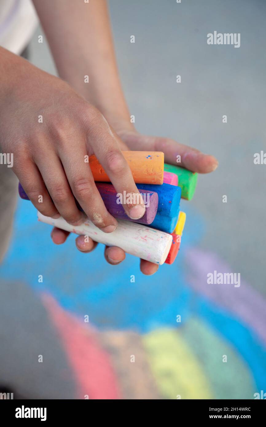 Chalks. Large multi-colored crayons in children's hands. The child ...