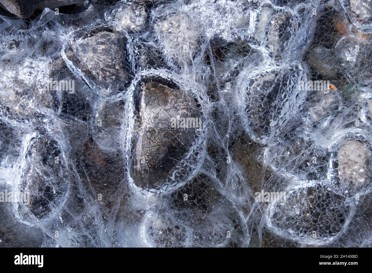 Natural winter background of frozen pebbles and hoarfrost crystals over ...