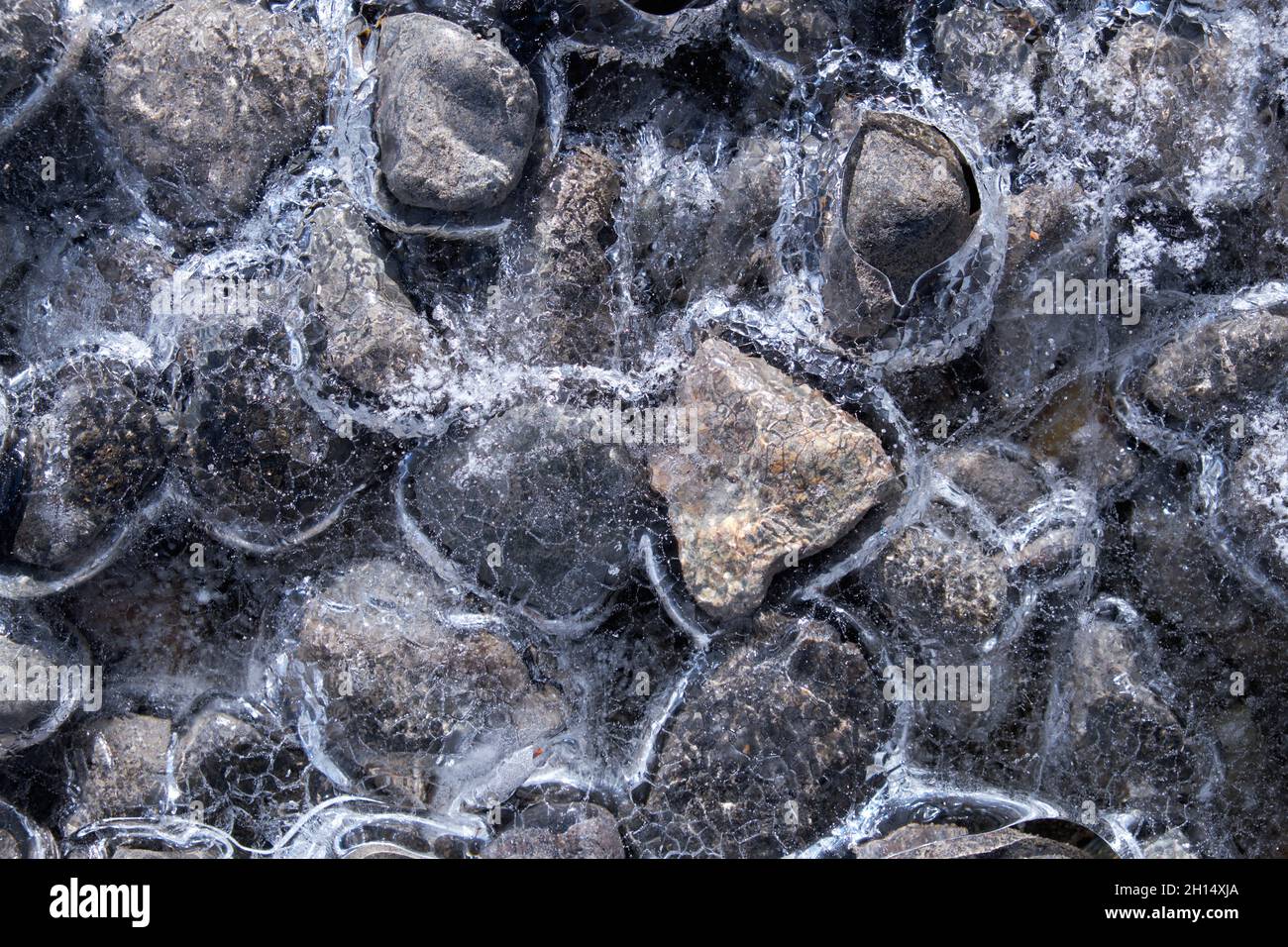 Natural winter background of frozen pebbles and hoarfrost crystals over ...