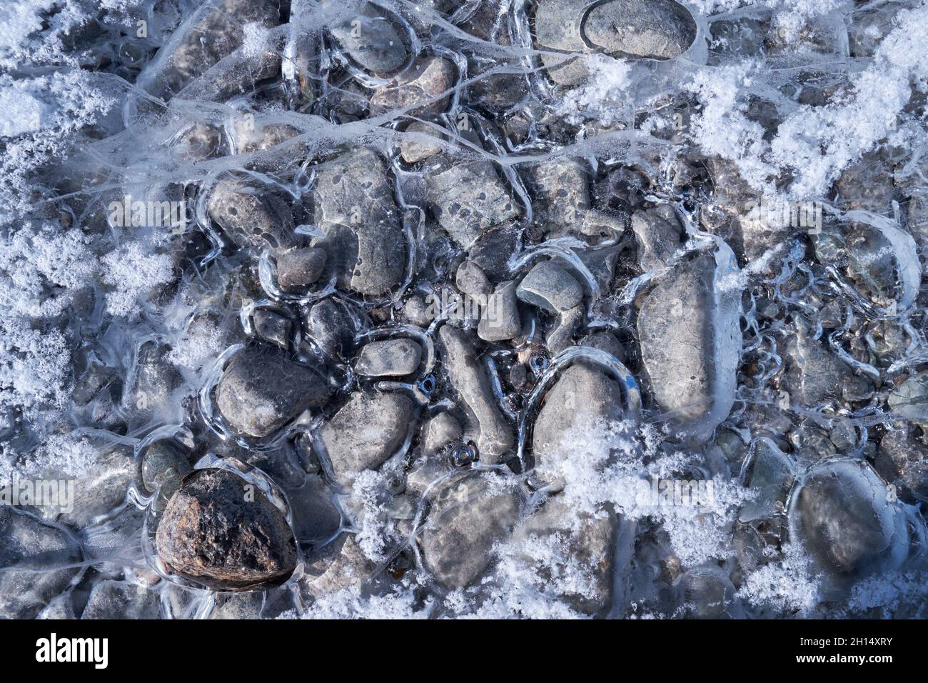 Natural winter background of frozen pebbles and hoarfrost crystals over ...