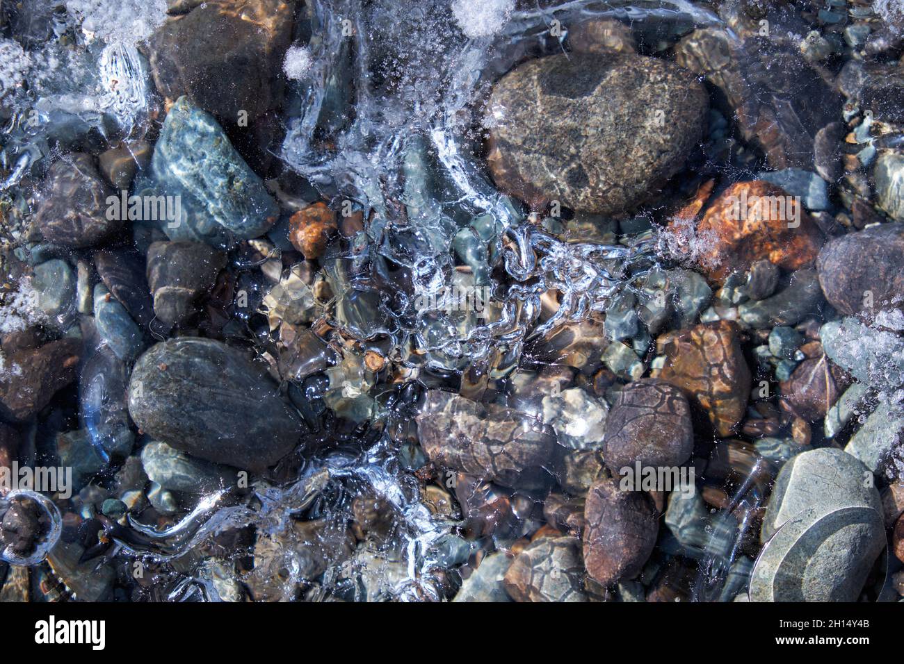Natural winter background of frozen pebbles and hoarfrost crystals over ...