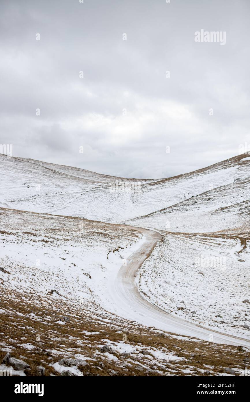 Snow-covered hilly landscape with winding roads Stock Photo - Alamy
