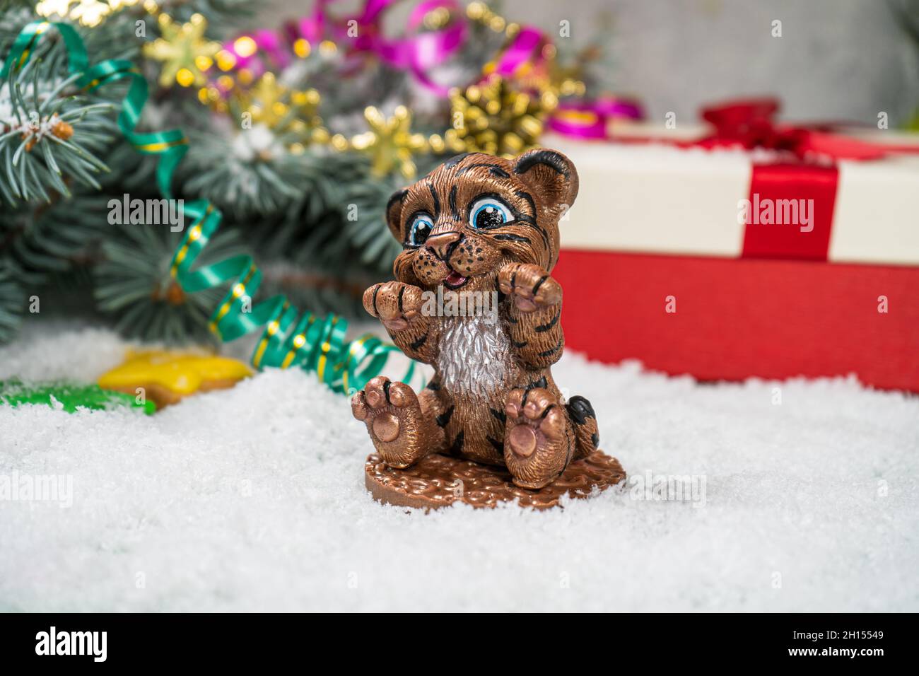 Christmas chocolate toy on snow. Chocolate toy in the shape of a tiger ...