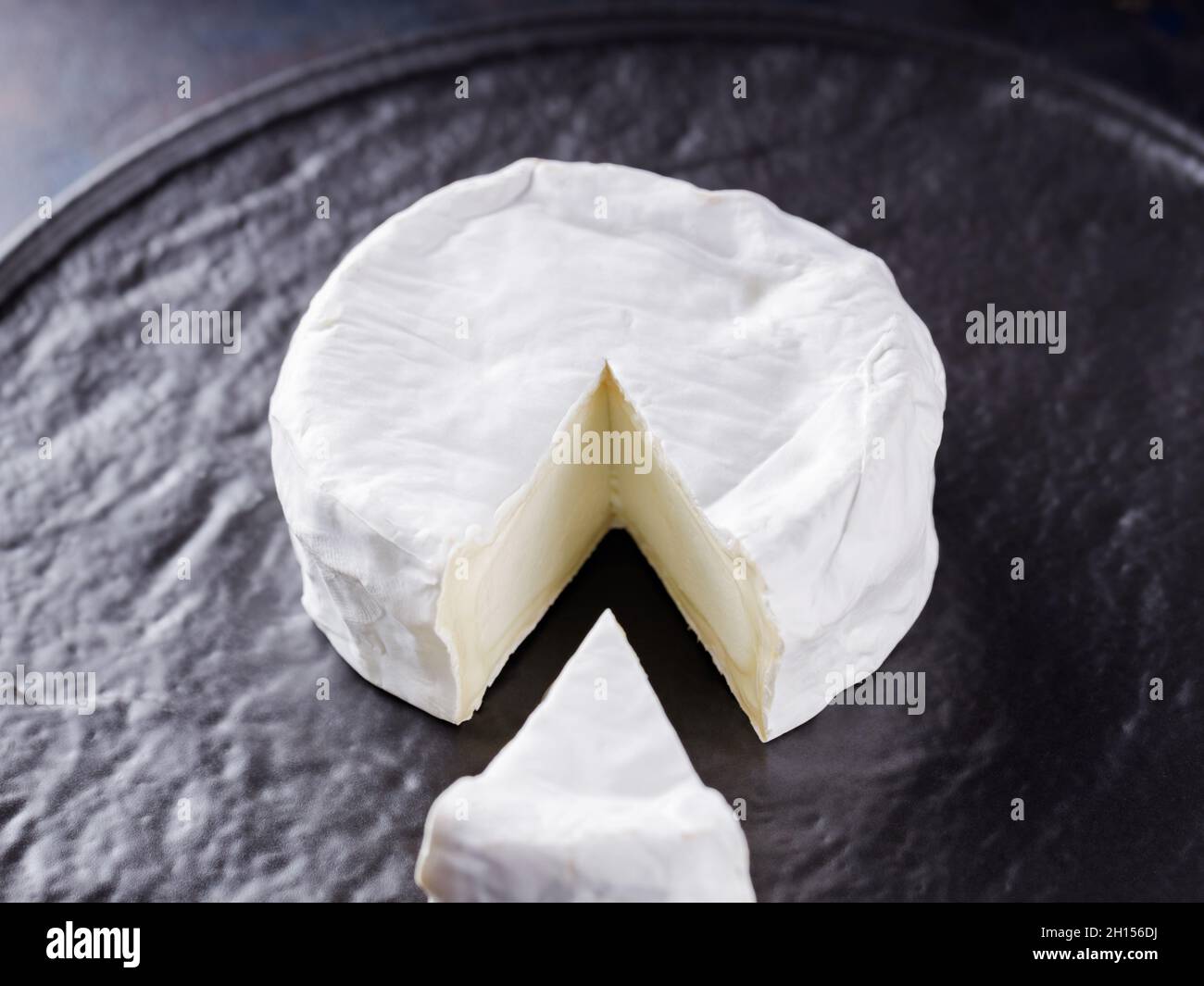 Camembert on a dark background. Soft cheese with white mold on a black ...