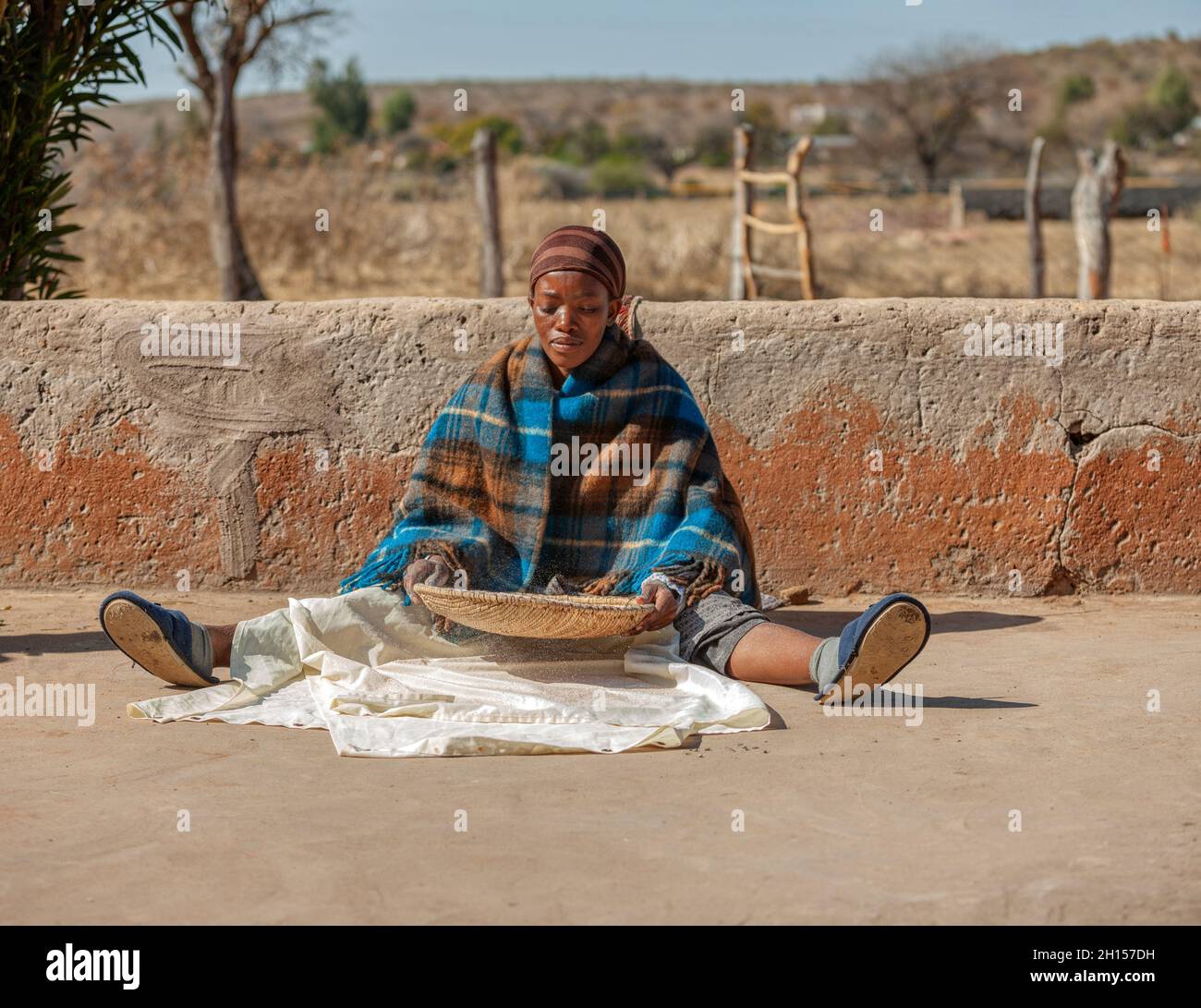 Old African woman grinding sorghum in a traditional way, in Botswana ...