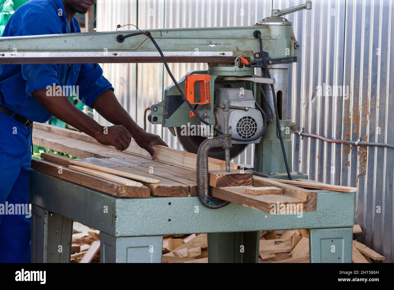 Wood working, African worker cutting wood industrial setting Stock ...