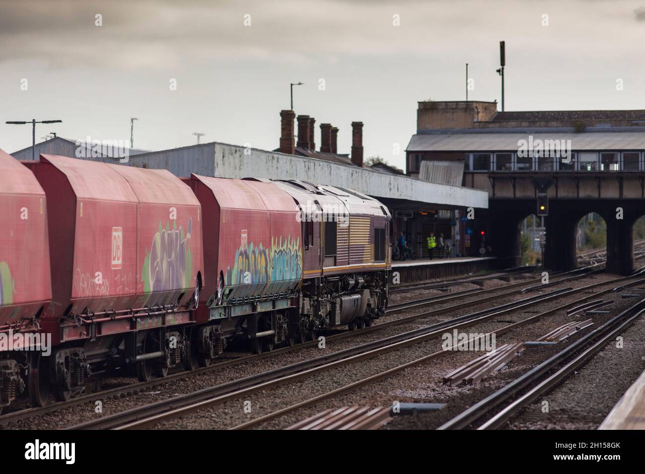 A diesel freight train with graffiti on its carriages passes through ...