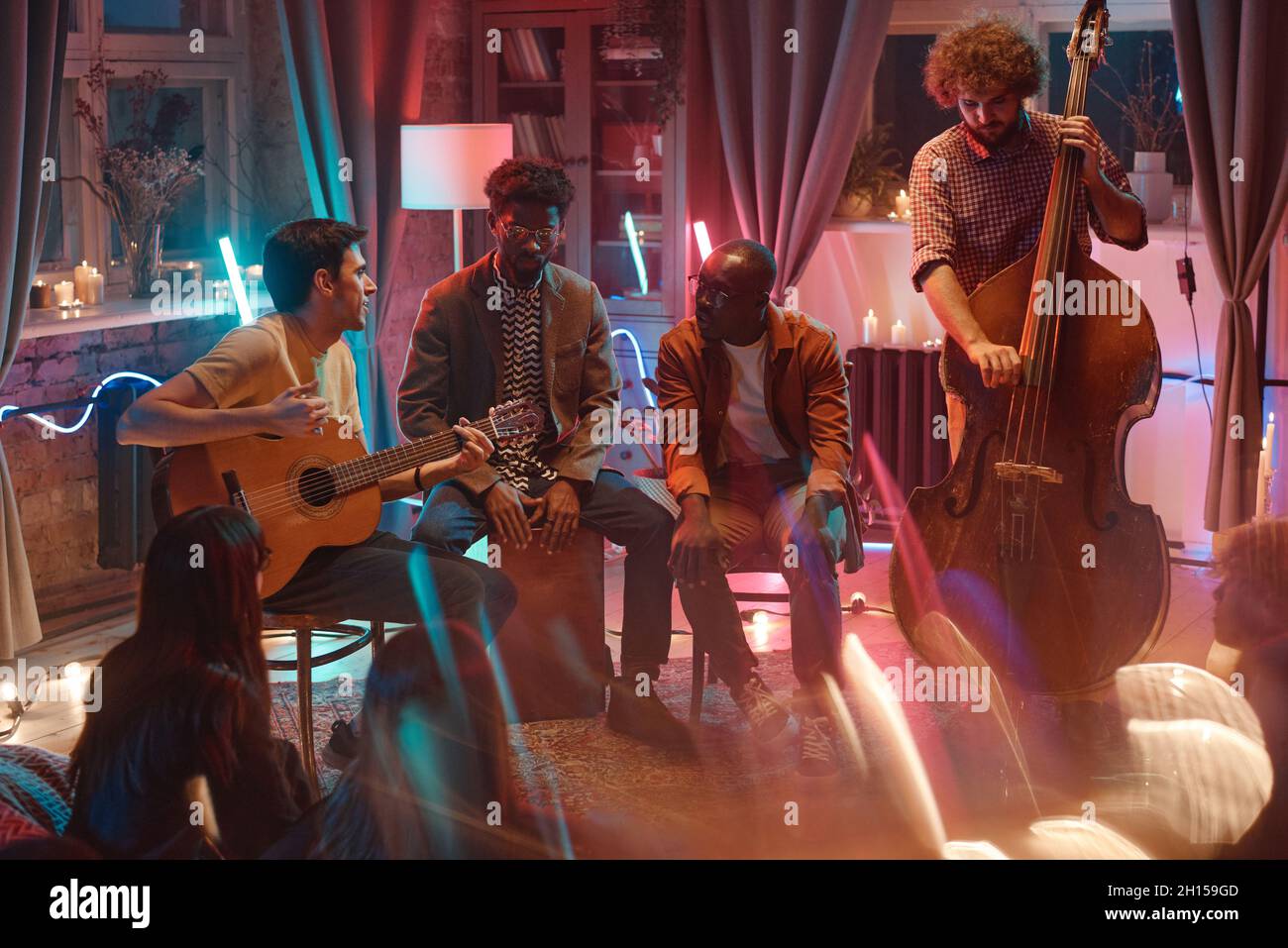 Group of young men performing in the club using musical instruments ...